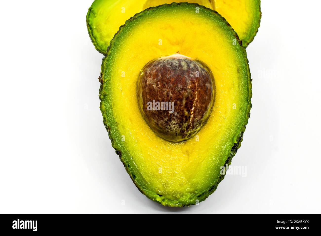 Close up of a ripe avocado cut in half isolated on a plain white ...