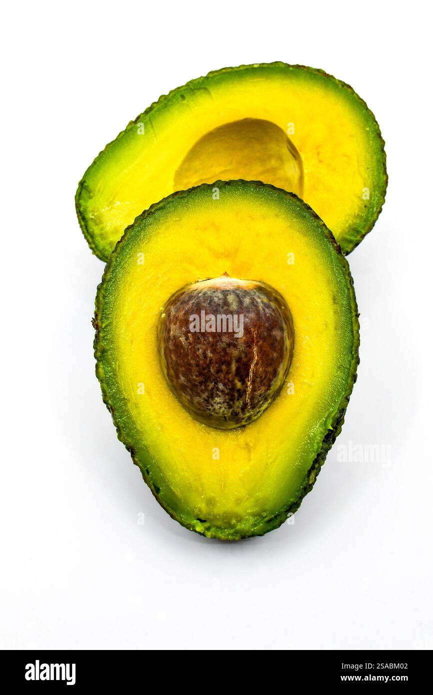 Close up of a ripe avocado cut in half isolated on a plain white ...