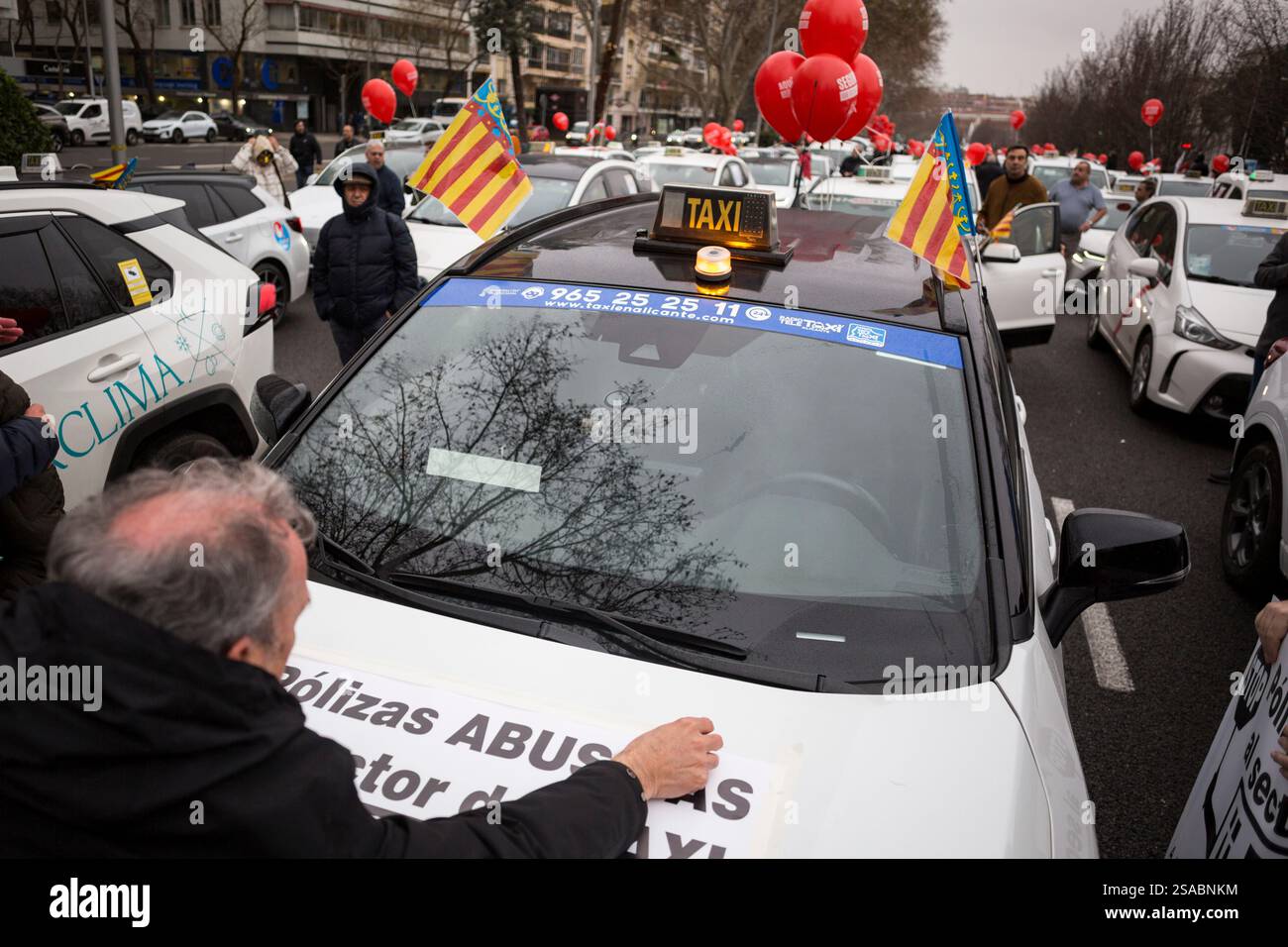 Madrid, Spain. 29th Jan, 2025. A taxi driver places a banner on the ...