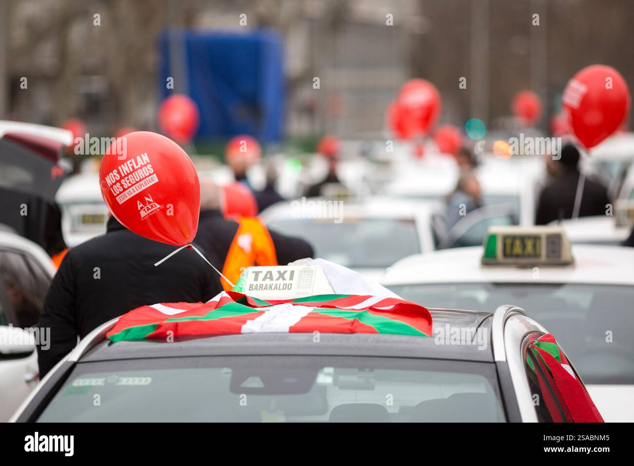 A red balloon hangs on the taxi next to a flag of the Basque Country ...