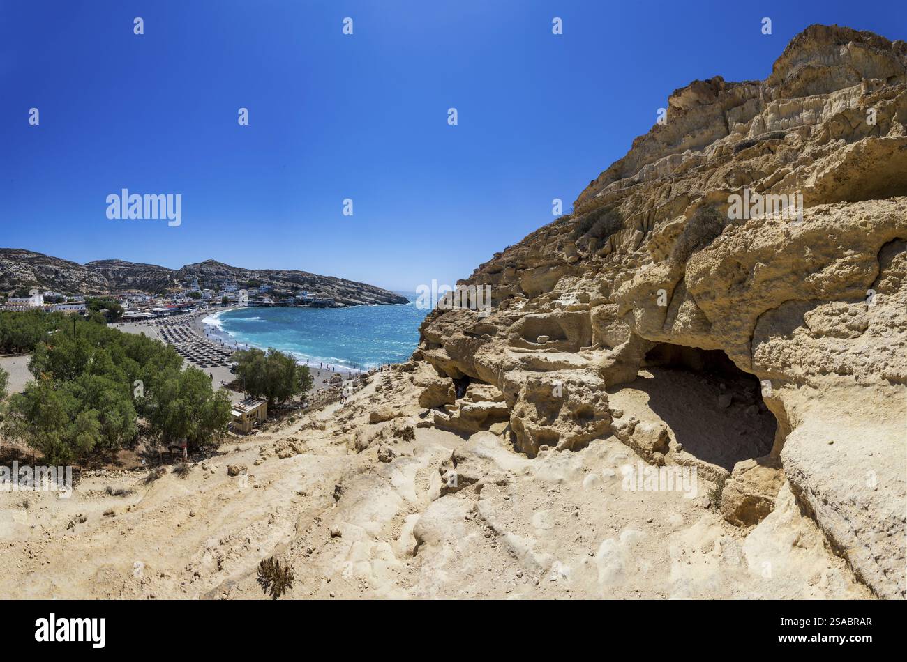 View from the rock caves to the beach of Matala, south coast, Crete ...