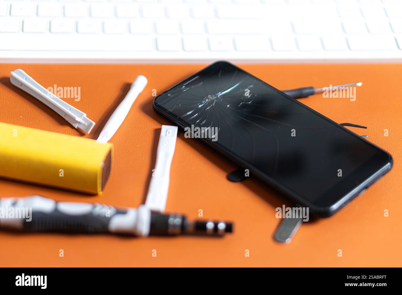 A collection of tools including a yellow device, screwdrivers, and ...