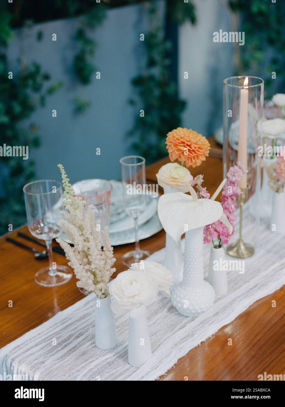 A beautifully arranged table showcases delicate floral centerpieces and elegant glassware ...
