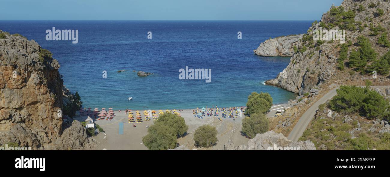 Wide bay of Ahata with pebbly beach and clear water, surrounded by high ...