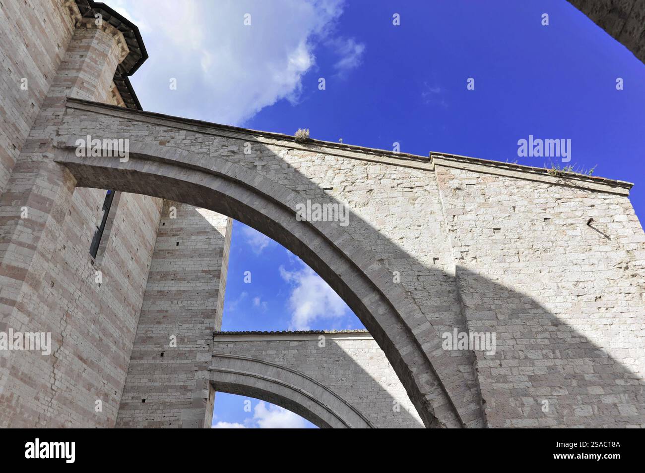 Stone arches of a historic building against a bright blue sky. Clear ...