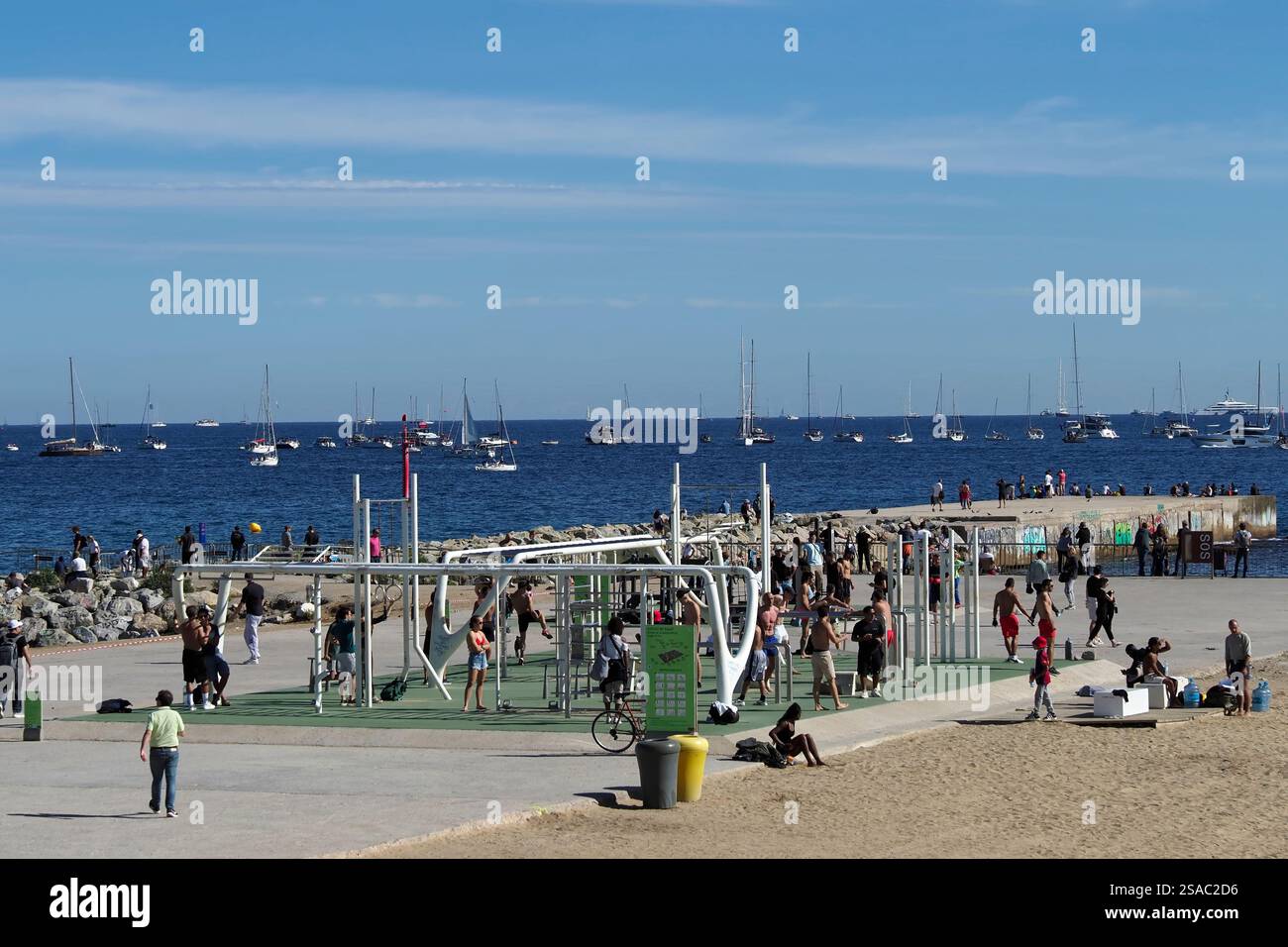 people exercise at a public open air gym on the beach in Barcelona ...