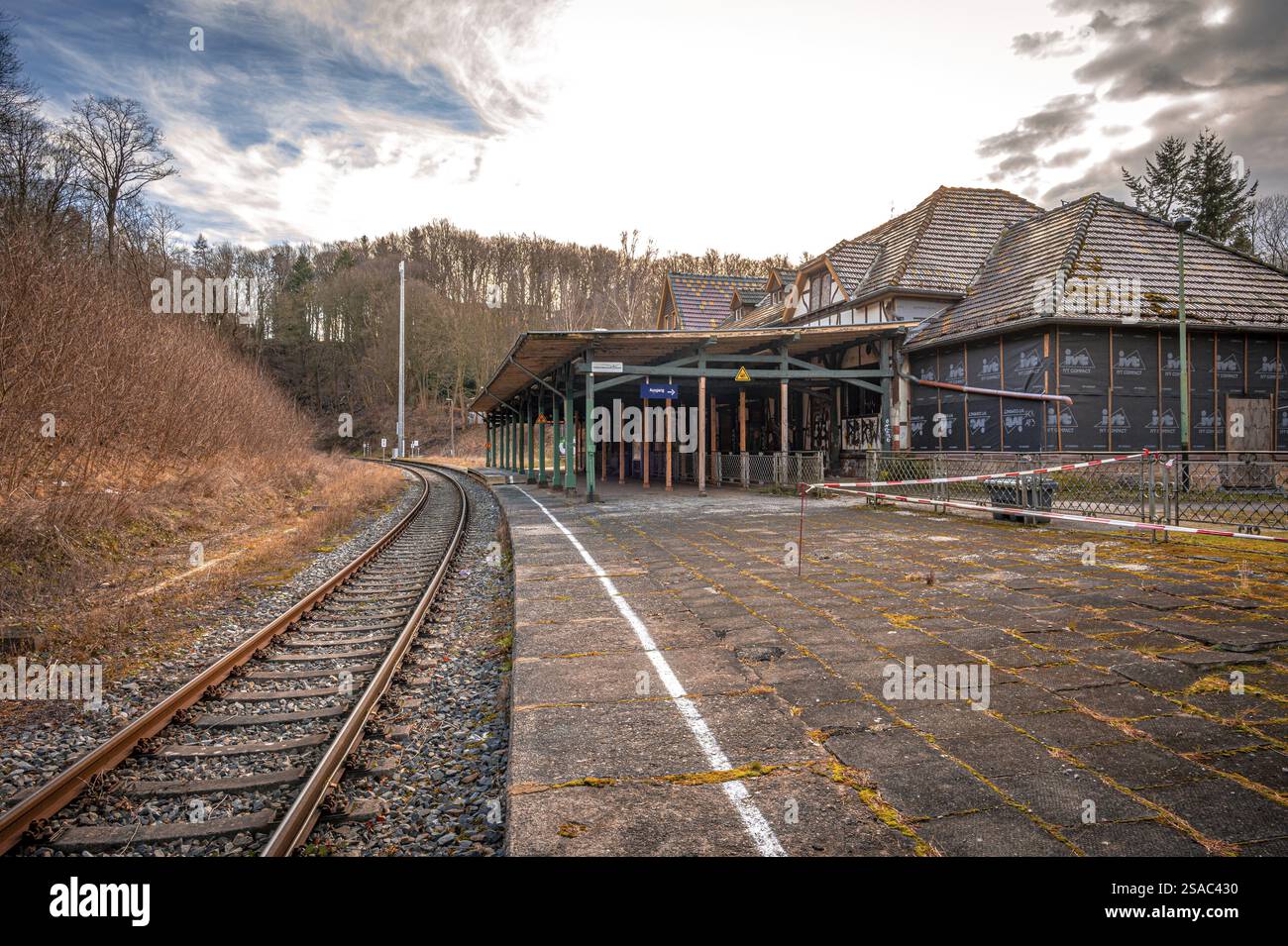 Historic railway station with tracks and weathered building, surrounded ...