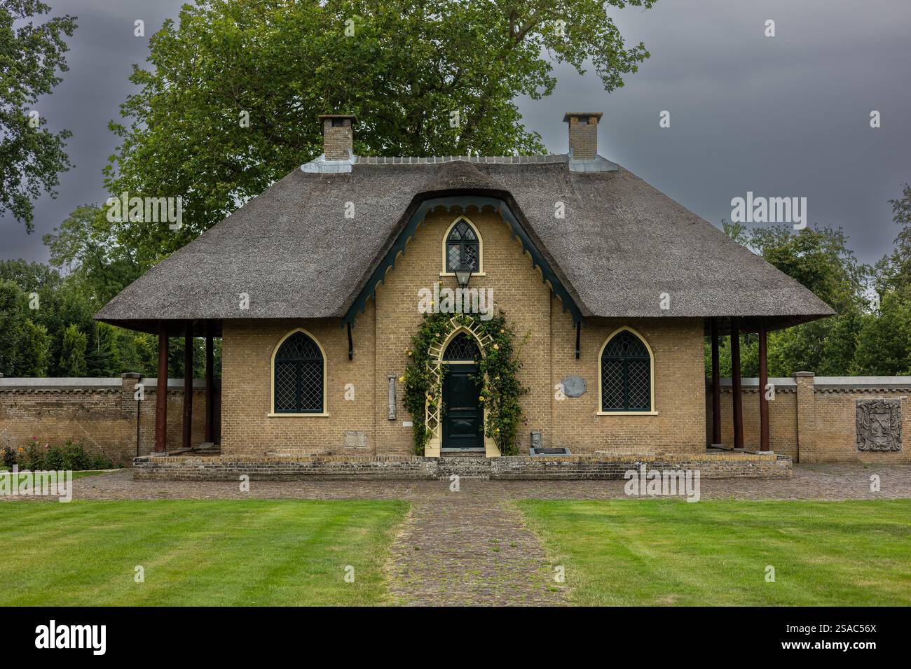 A charming brick house with a thatched roof, arched windows, and a ...