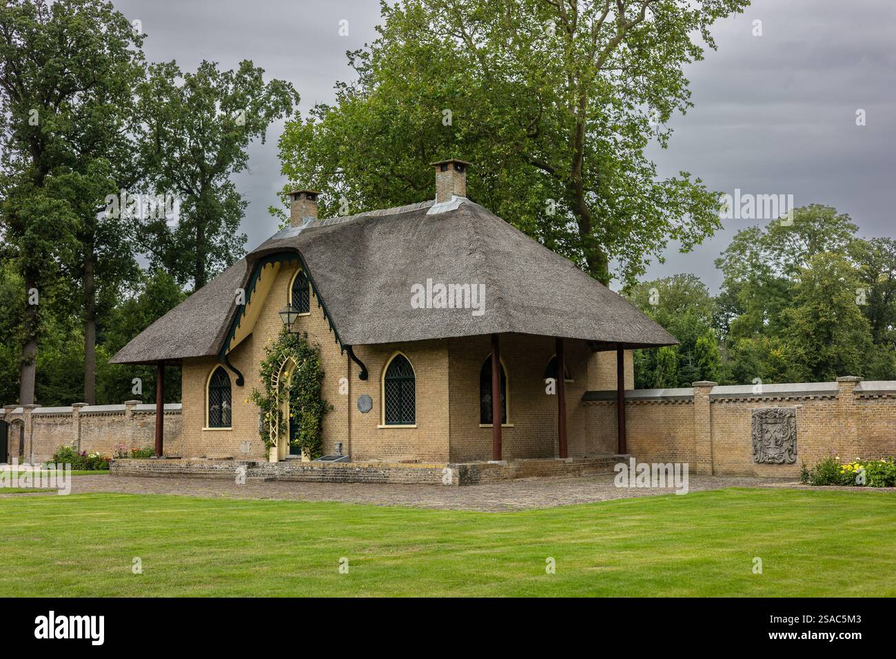 A charming brick house with a thatched roof, arched windows, and a ...