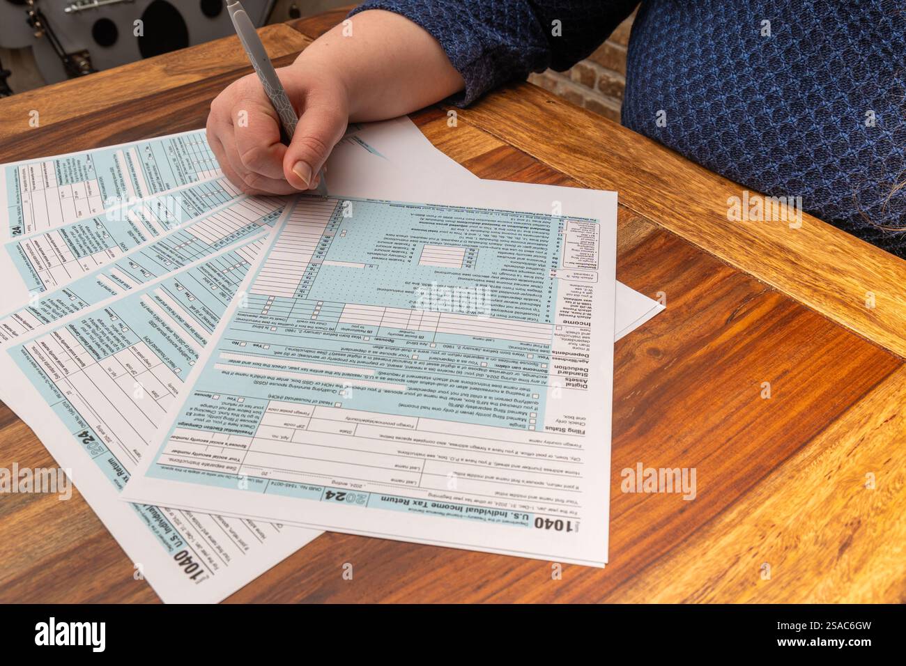 Perplexed Woman focused on completing 1040 US income tax form in a cozy ...