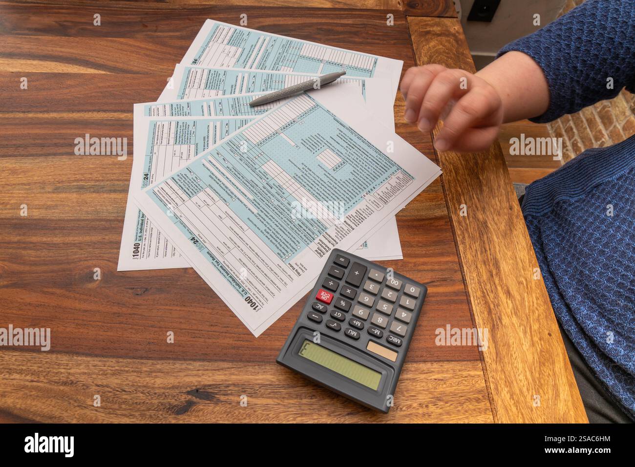 Perplexed Woman focused on completing 1040 US income tax form in a cozy ...