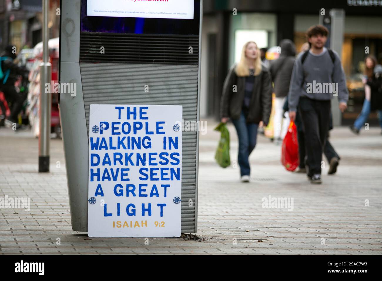 People walk through the cty centre of Leeds in west Yorkshire with a ...
