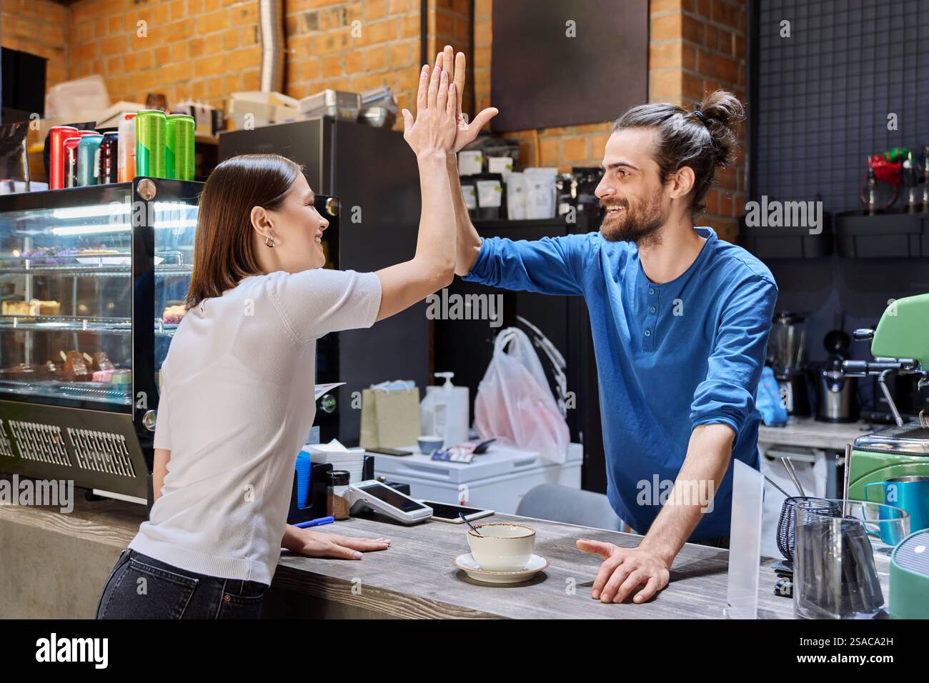 Young man cafe worker shaking hands with woman client customer ...