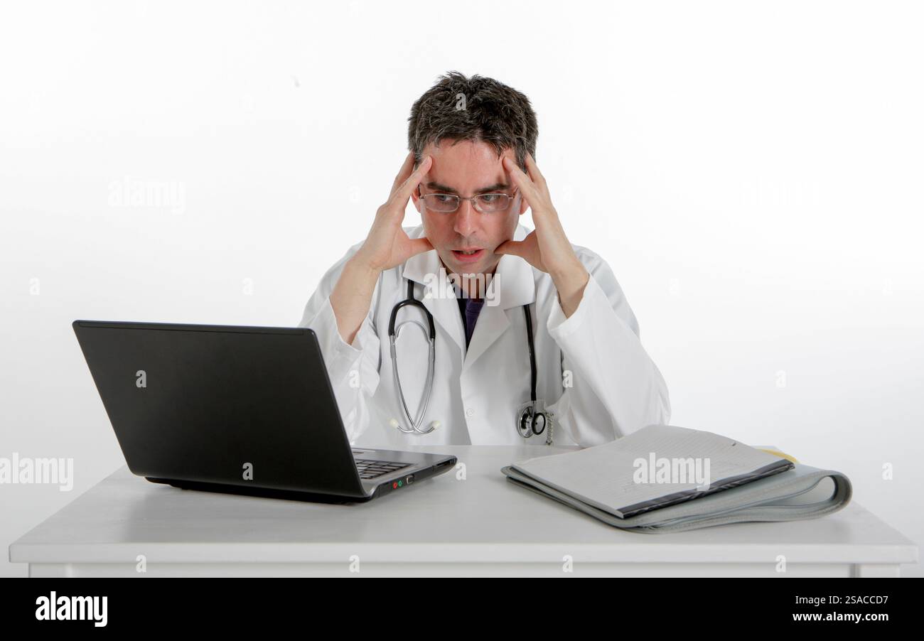 Medical Admin: Frustrated Doctor. A doctor sitting at his desk looking ...