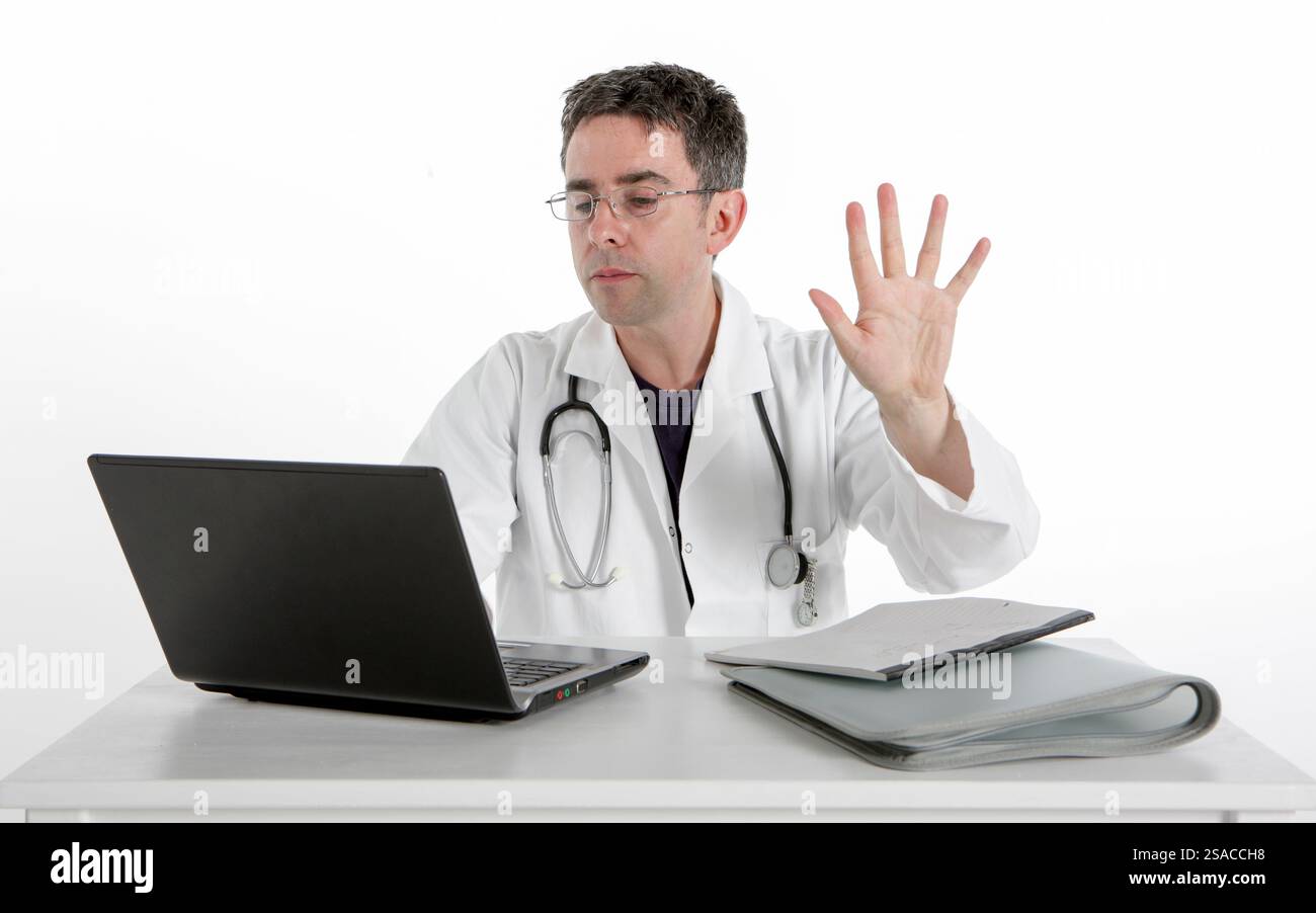 Medical Admin: Busy Doctor. A doctor sitting at his desk holding up a ...