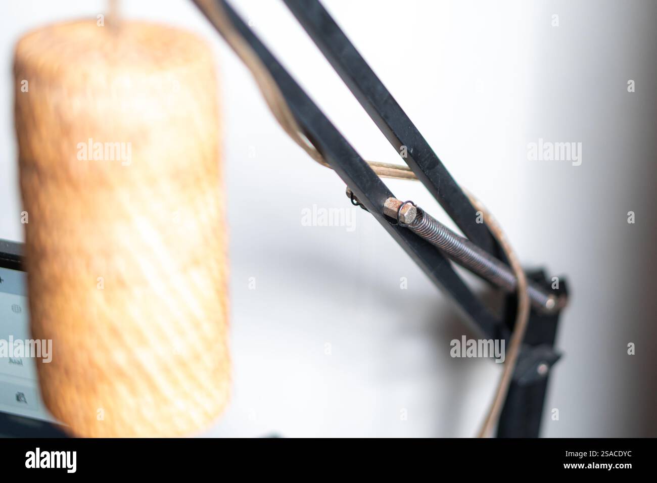 A close-up view of a mechanical arm with a textured cylindrical object ...