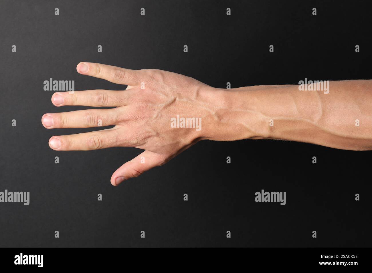 Man with bulging veins on his arm against black background, closeup ...
