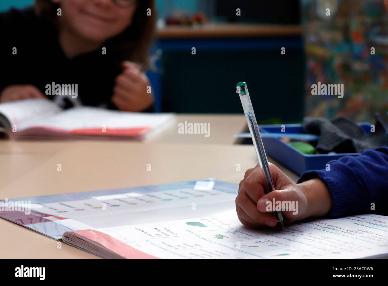 Primary school child writing on a desk during a lesson. France Stock ...