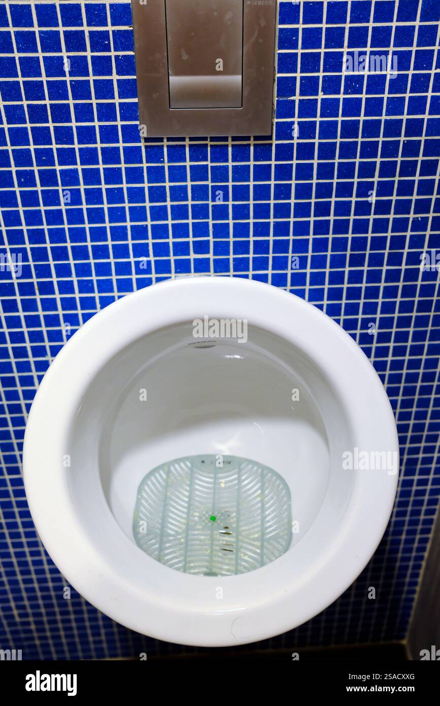 White urinal in men public toilet. Ceramic urinals in men restroom. Man ...