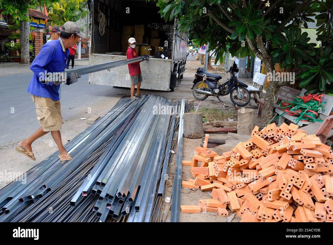 Steel concrete reinforcement bars. Construction site. Vietnamese worker ...