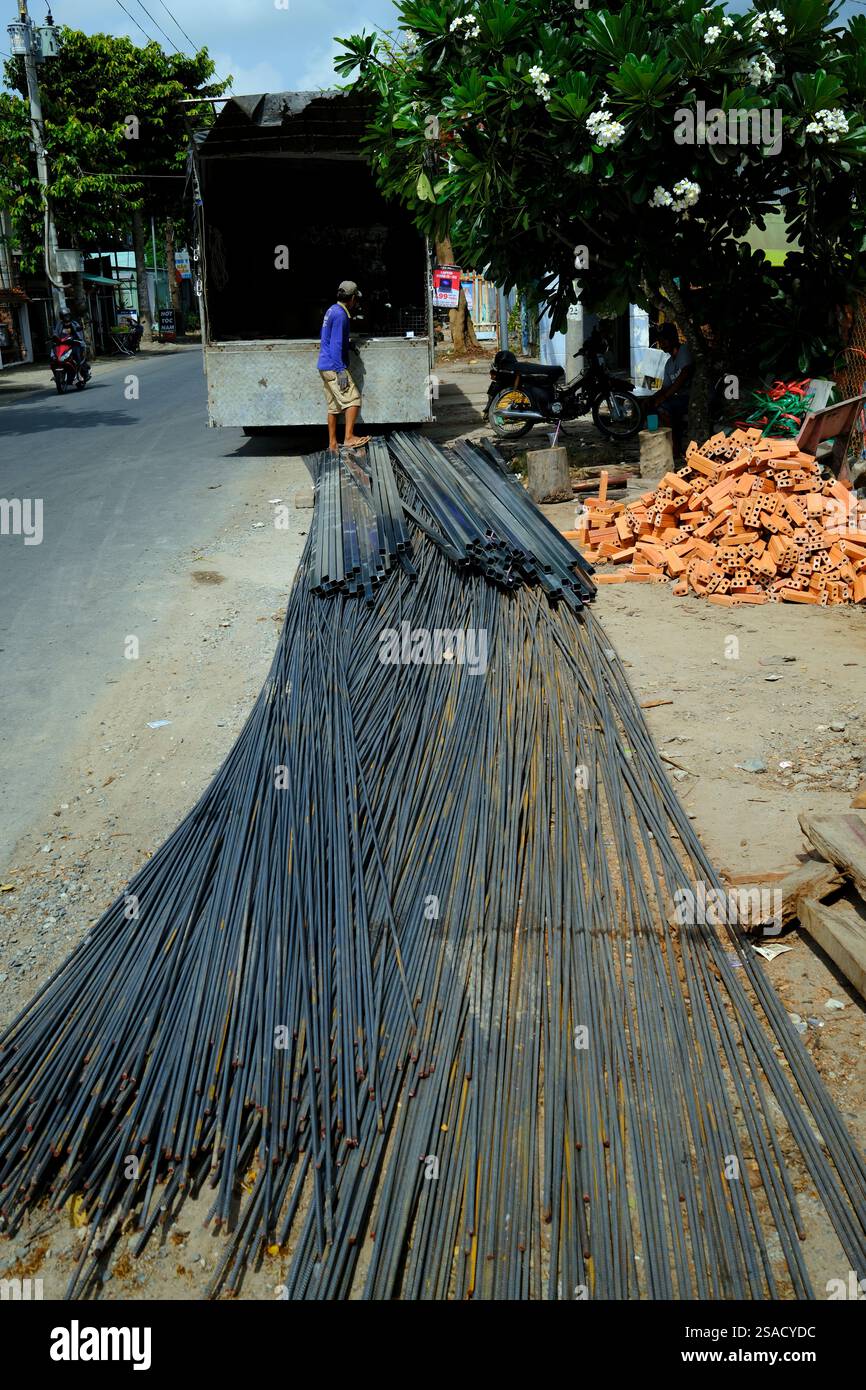 Steel concrete reinforcement bars. Construction site. Vietnamese worker ...