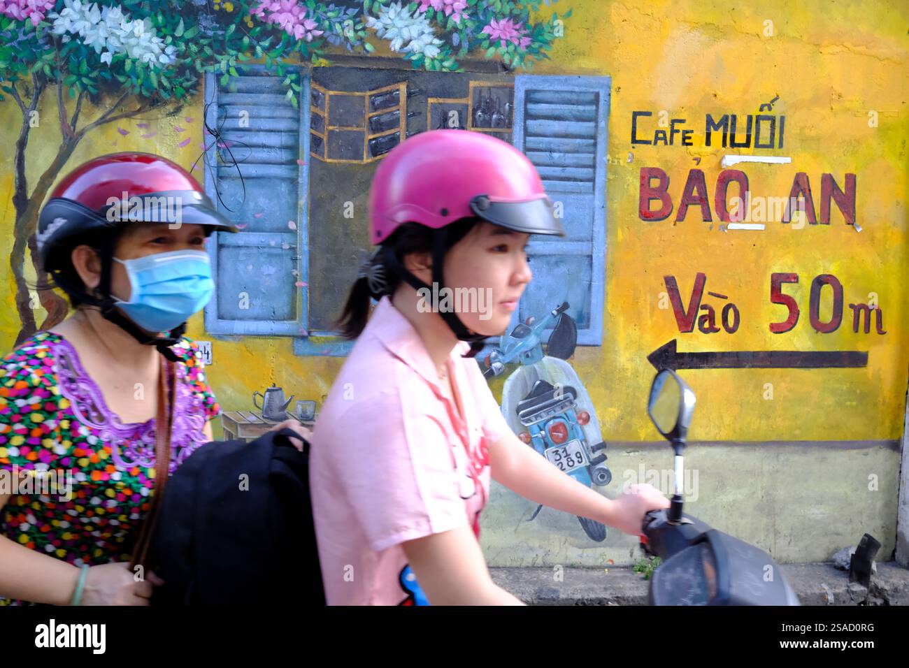 Vietnamese people riding a scooter on the street. Ho Chi Minh City ...