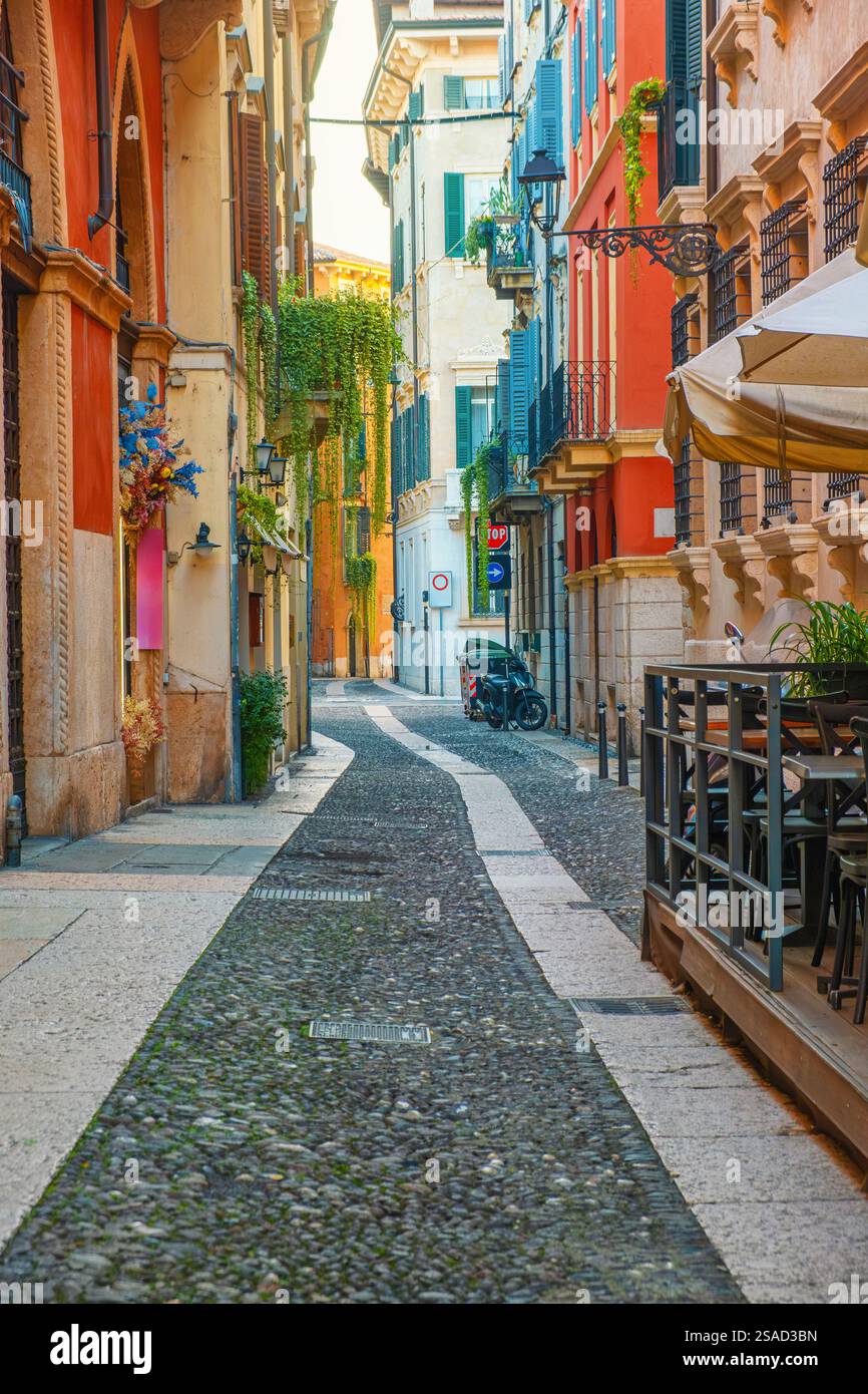 Italian narrow street with colorful building facades and cobblestone ...