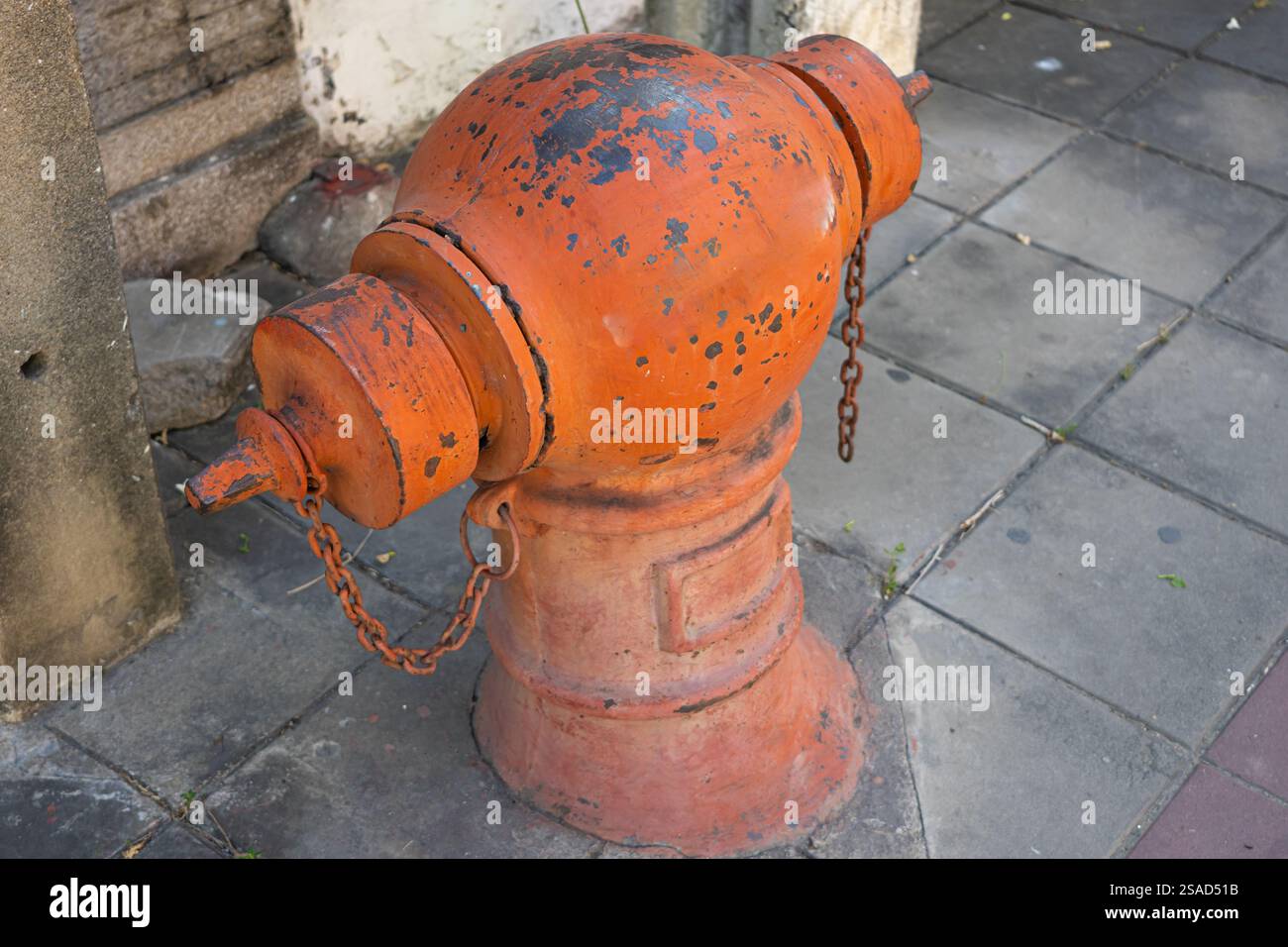 An orange fire hydrant with worn paint. Ideal for urban security ...