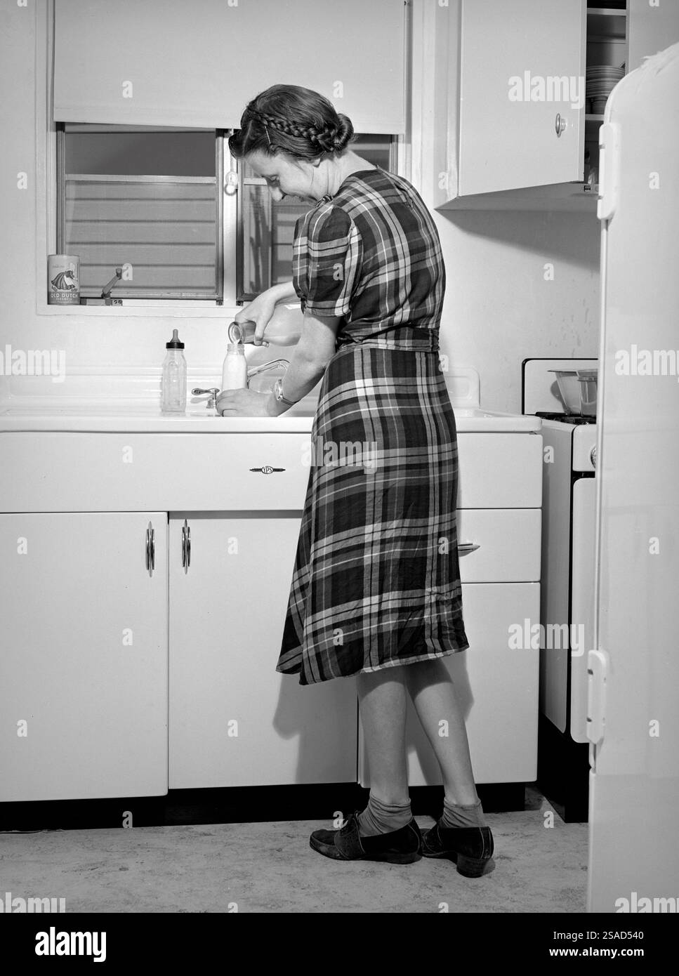 Mother preparing baby's bottle, Kearny Mesa defense housing project ...
