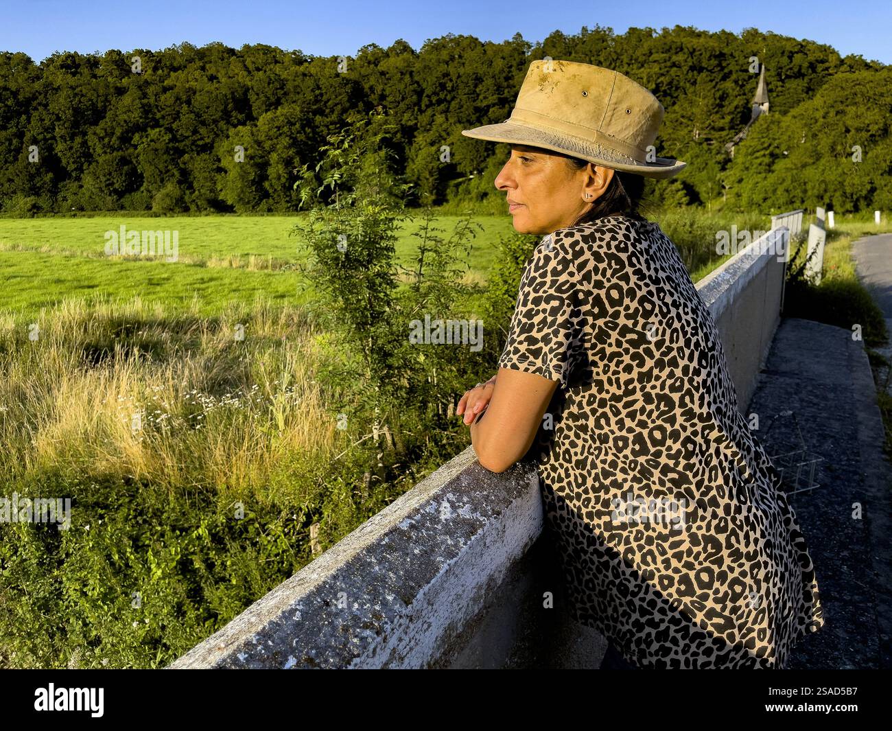 Woman enjoying the view of the Risle river from a bridge in ...