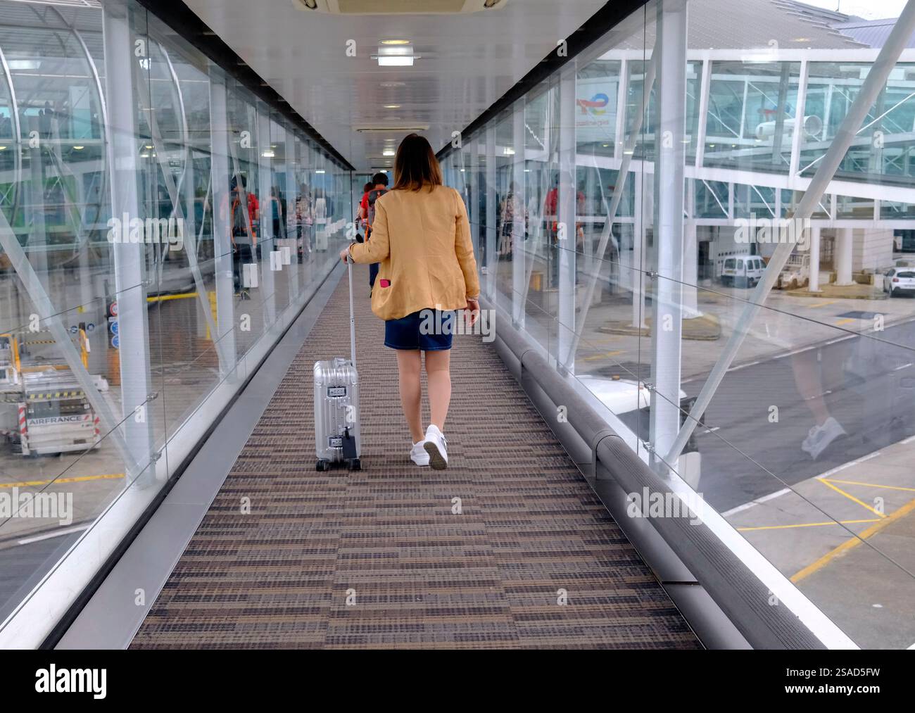 Airport. Woman traveling with a metal suitcase. Transit. Roissy. France ...