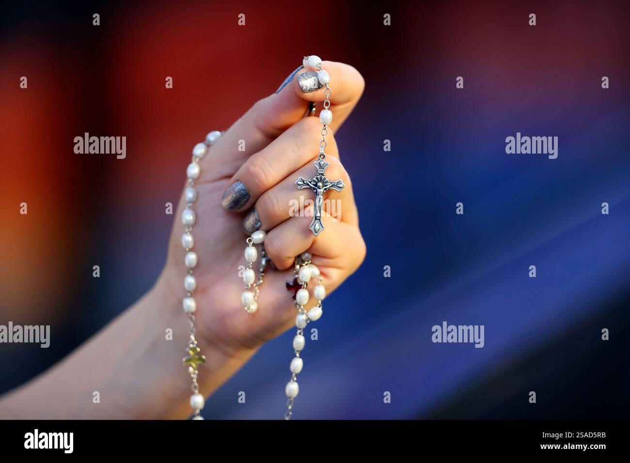 Catholic woman praying the Rosary in a church. Close up on hands and ...