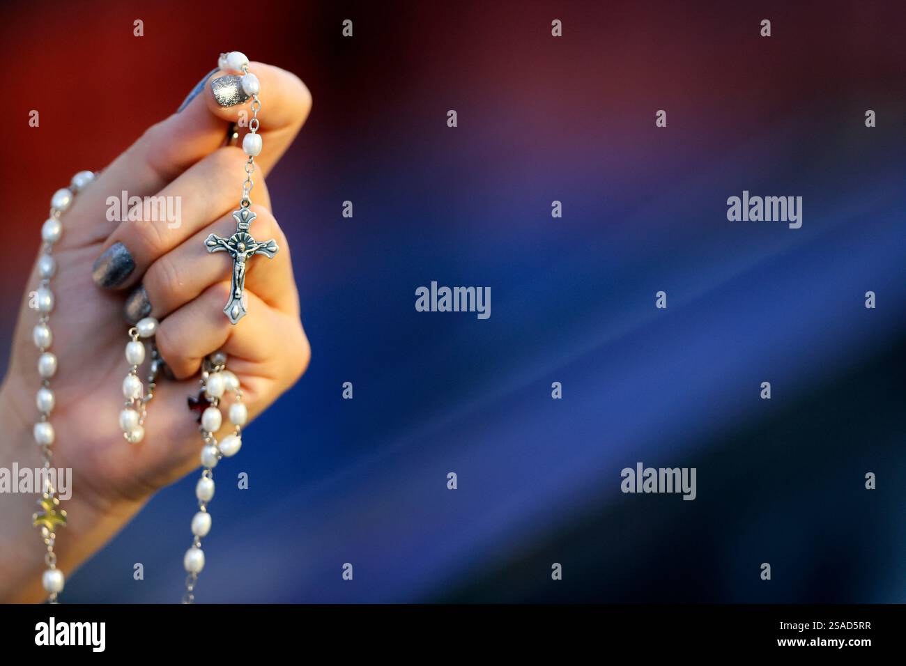 Catholic woman praying the Rosary in a church. Close up on hands and ...