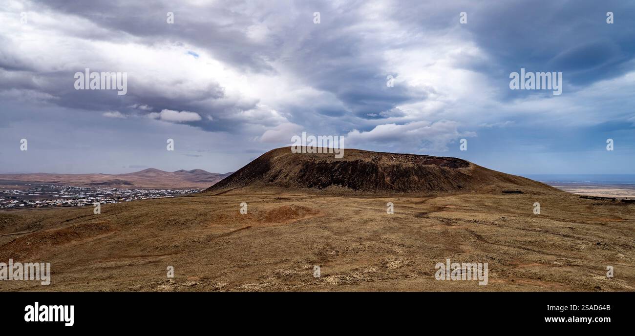 A panoramic view of a barren landscape featuring a prominent hill under ...