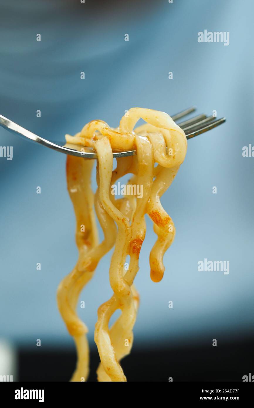 Fork holding strands of noodles with a simple background Stock Photo ...