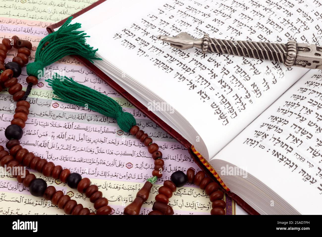 Torah scrolls in Hebrew, yad, quran in Arabic and prayer beads ...