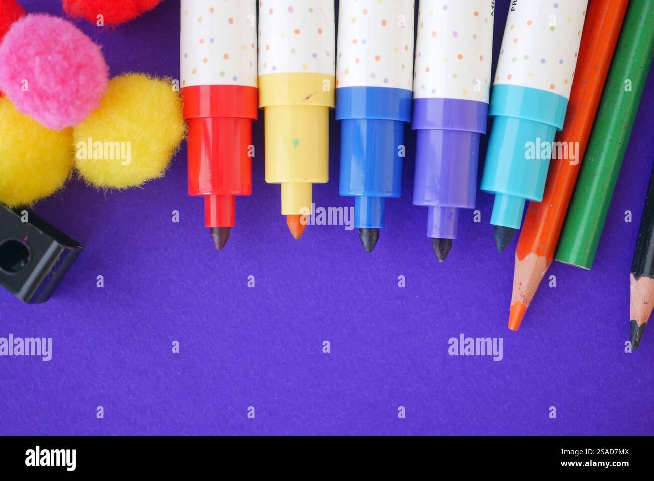 Colorful art supplies arranged on a purple surface Stock Photo - Alamy
