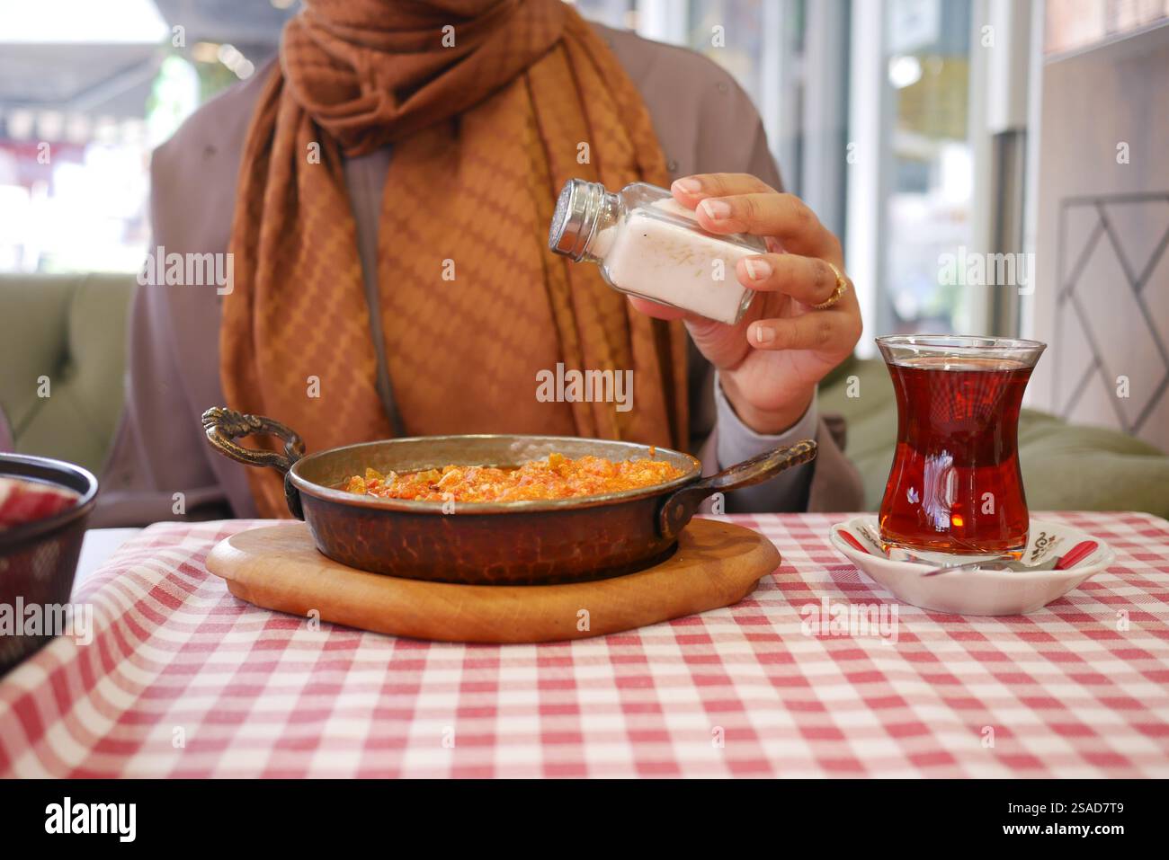 woman pouring salt on Turkish Menemen omelet in a frying pan Stock ...