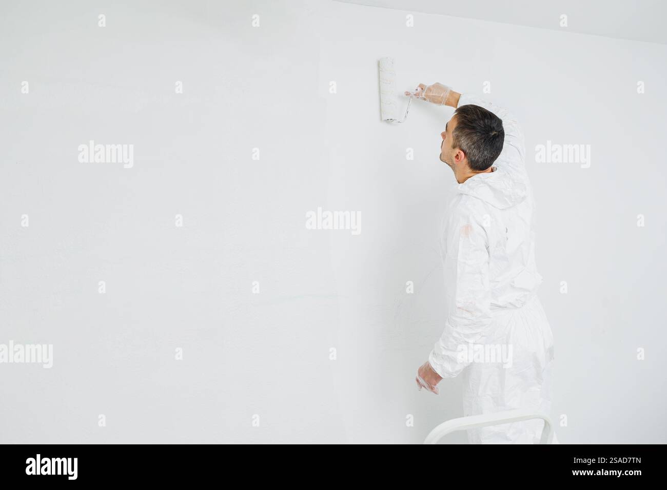Man doing house renovation. Industrial theme. Painting walls. Builder ...