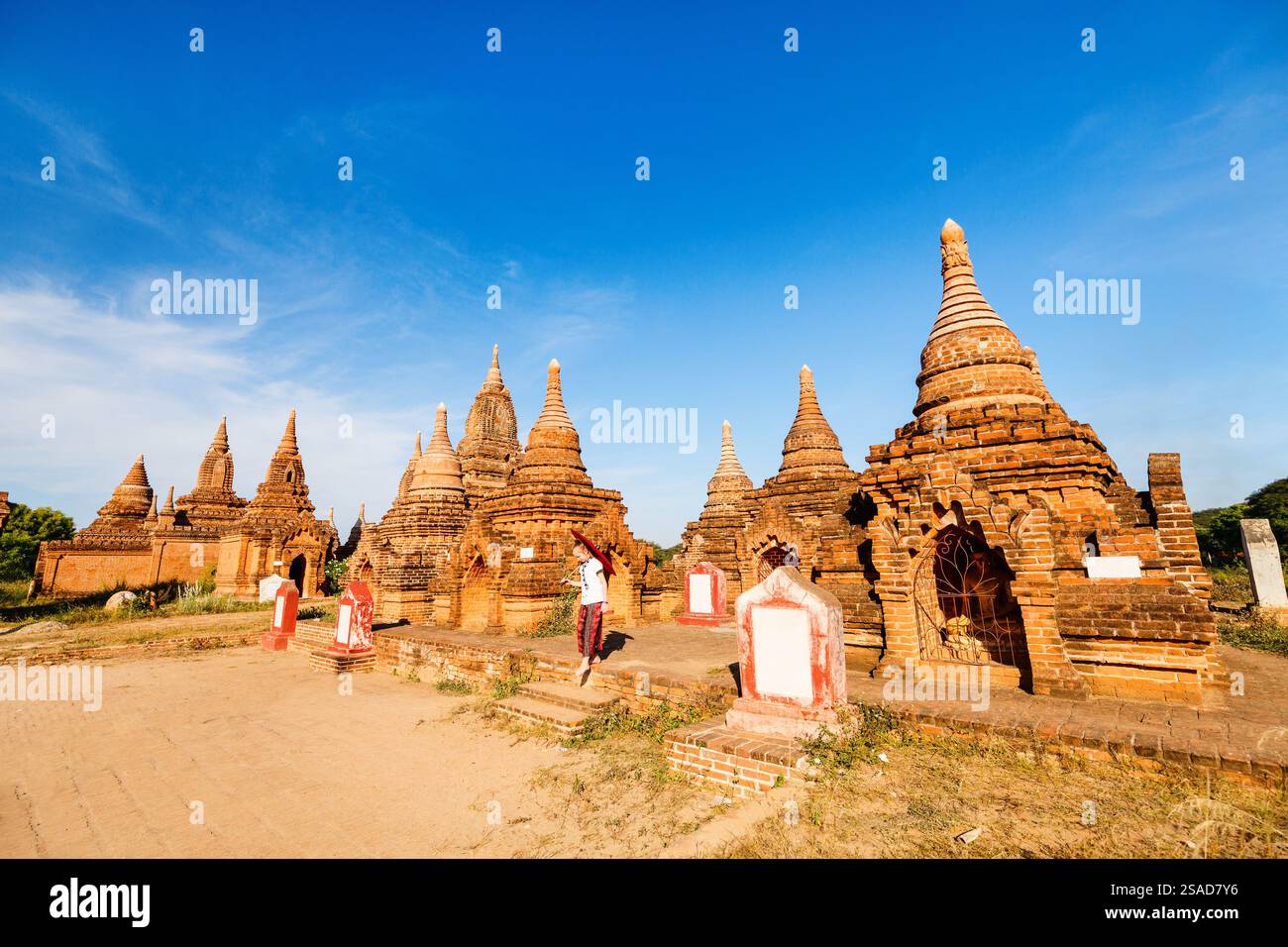 Young girl with traditional burmese parasol visiting ancient temples in ...