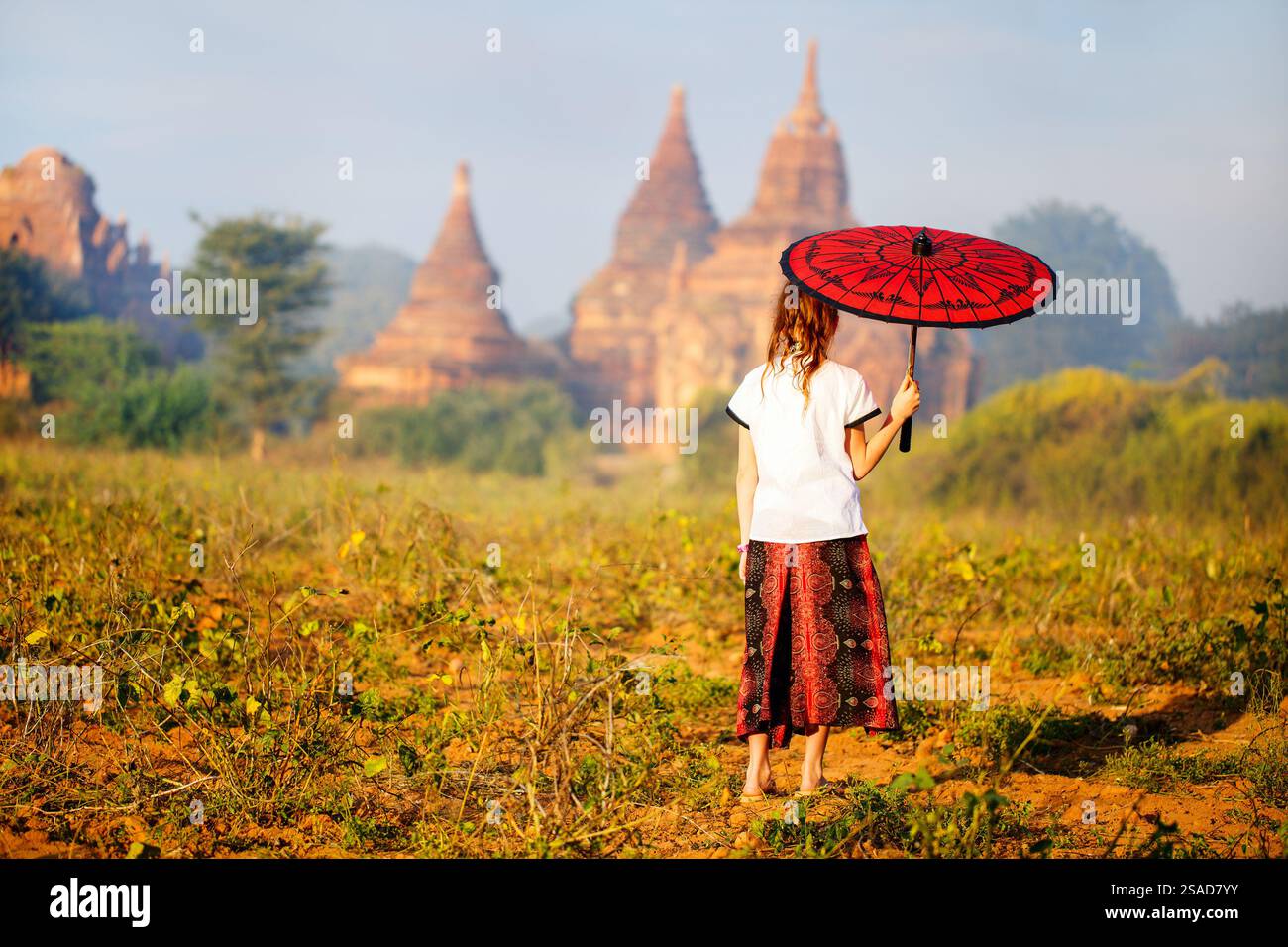 Back view of young girl with traditional burmese parasol visiting ...
