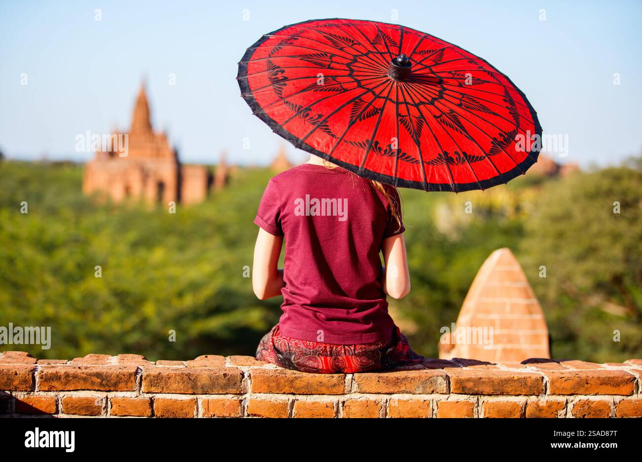 Back view of young girl with traditional burmese parasol enjoying ...