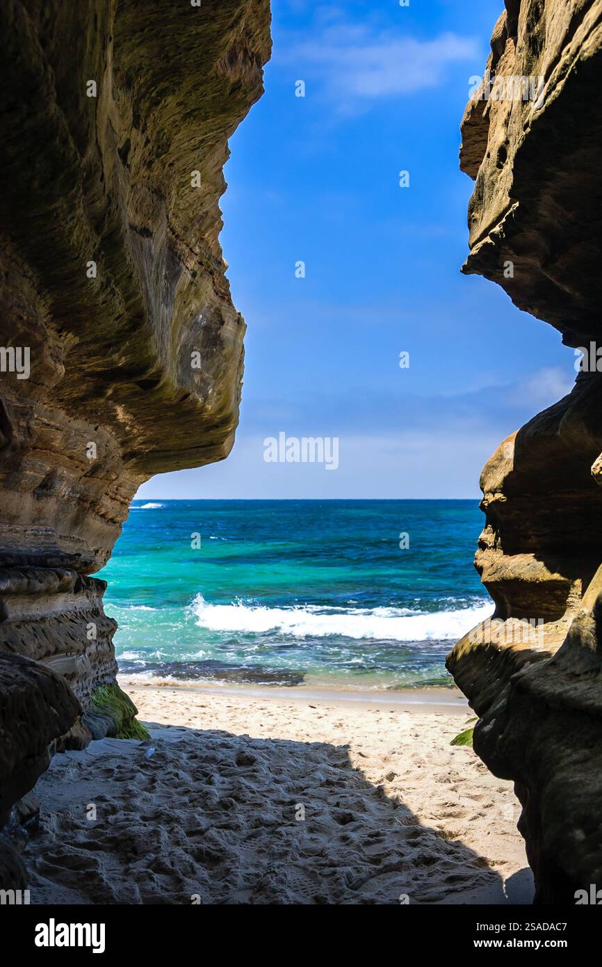 A rocky cliff overlooks the ocean, with the water appearing calm and ...