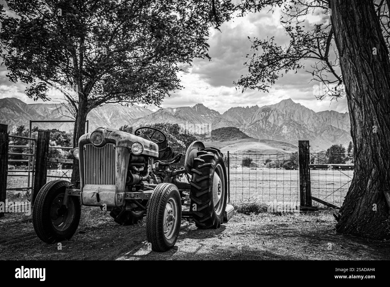 An old tractor on a farm near the Sierra Nevada mountain range. In ...