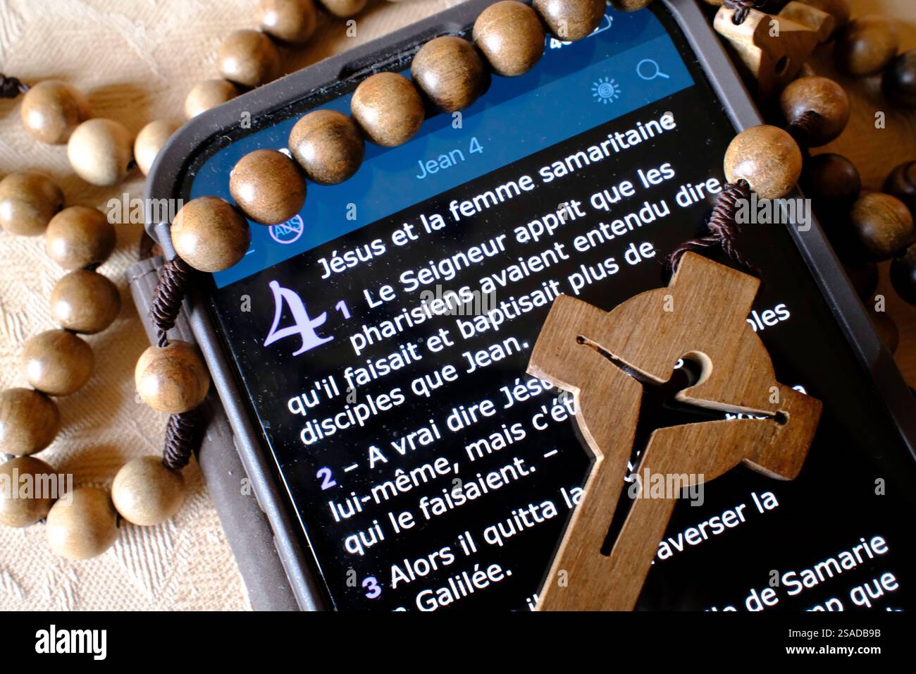 Rosary and digital bible on a smartphone. New testament. .Jesus and the ...