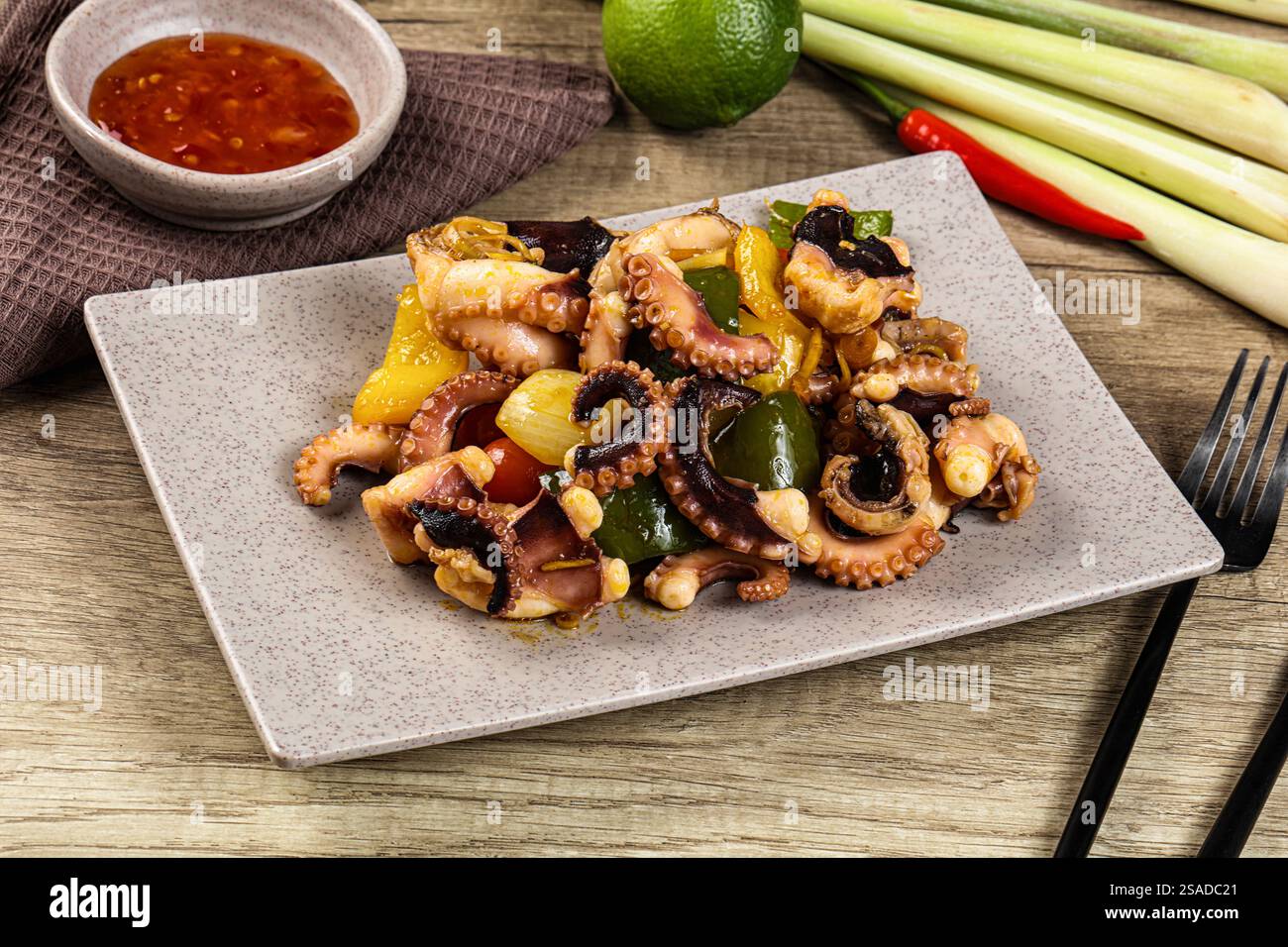 Roasted octopus with vegetables, spices and oil Stock Photo - Alamy