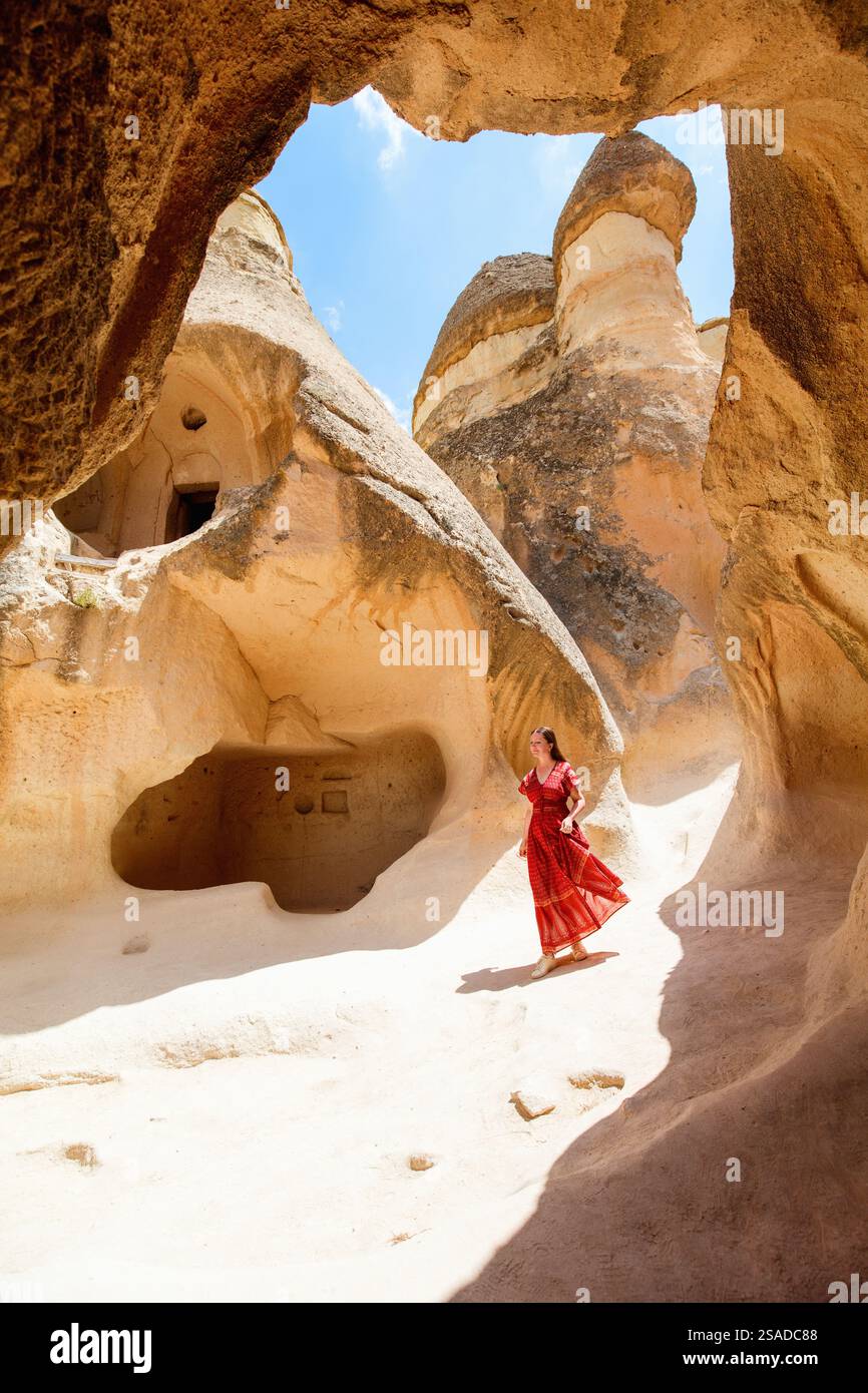 Young beautiful woman in red dress exploring Pasabag Monks valley in Cappadocia Turkey with ...
