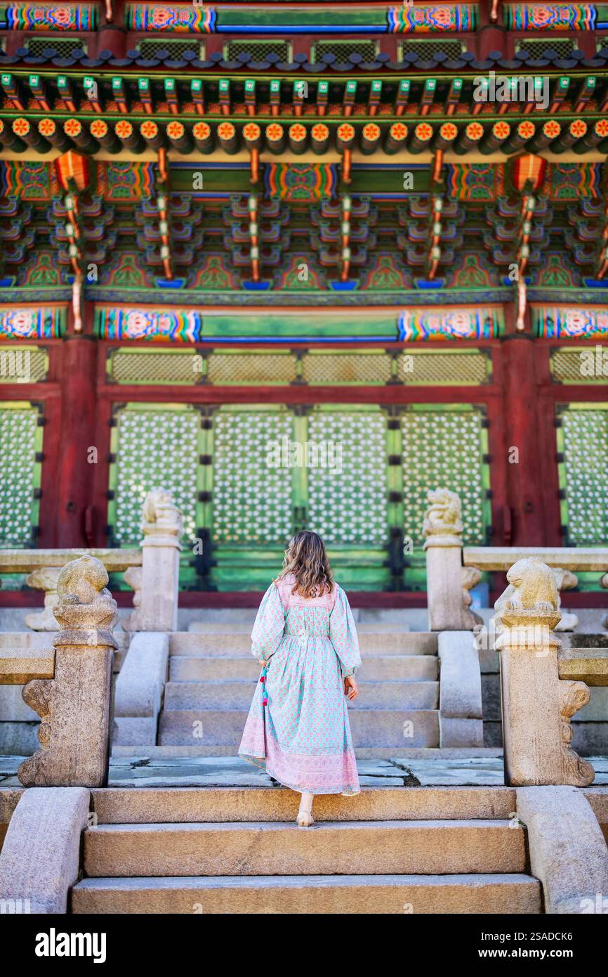 A tourist walks up stone steps towards the intricate wooden structure ...