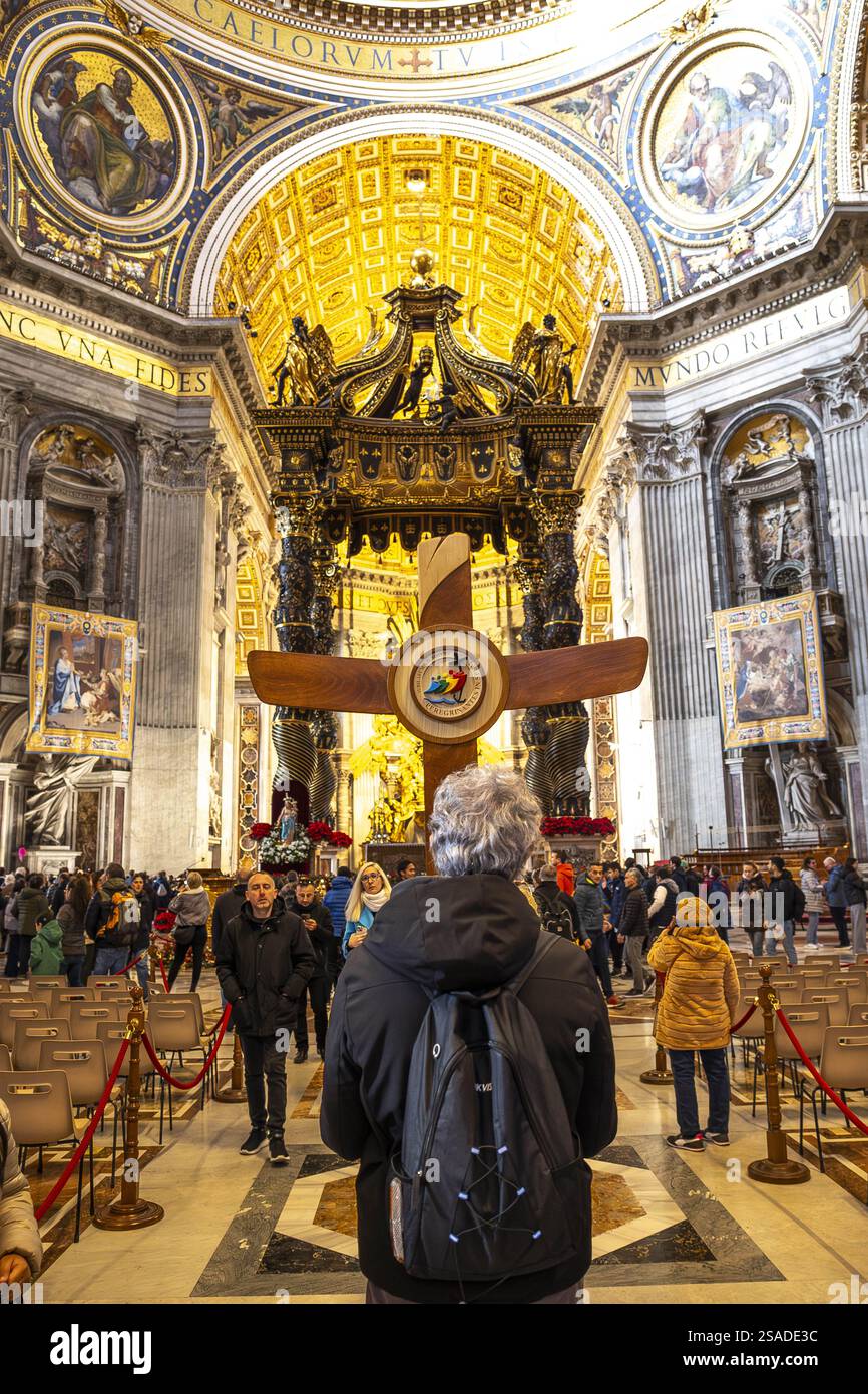 Pilgrim carrying Jubilee cross in St. Peter's basilica during the ...