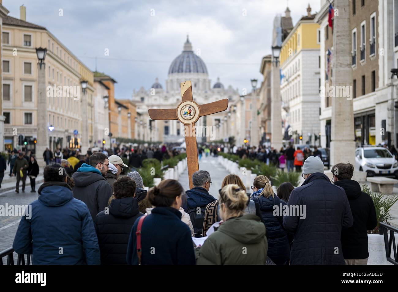 Pilgrims carry a cross on the via della Concillazione which leads to ...